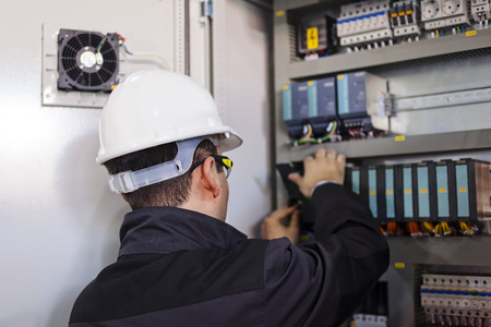 Closeup man worker checking advanced industrial control panel; note ...