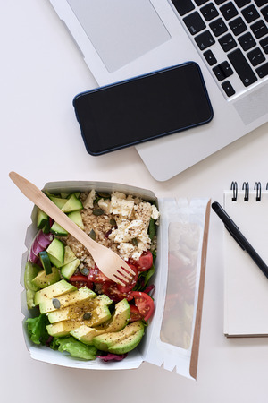 Laptop computer, mobile cell phone and healthy takeout salad, for food ...