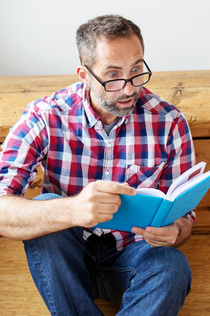 Handsome smiling man reading a book Images - Search Images on Everypixel