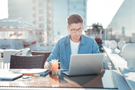 Smart gentleman wearing casual attire sitting on a terrace of a cafe ...