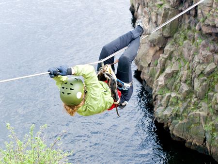 A female climber crosses a gorge along a tyrolean traverseの写真素材 ...