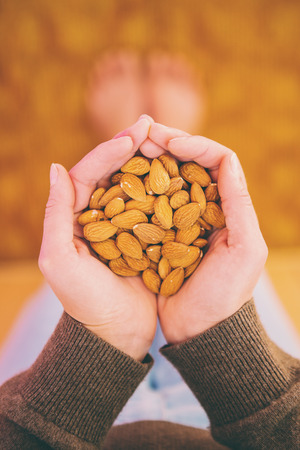 A handful of almonds in female hands. A useful nut. Proper nutrition ...