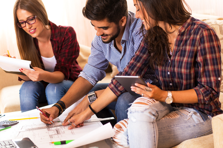 Three young students working together on a new project. Start up ...