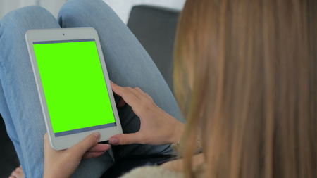 Woman using vertical tablet computer with green screen. Close up shot ...