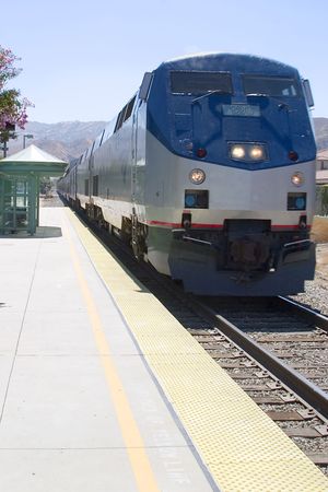 Commuter train arriving at station to pickup passengers. - Stock Image ...