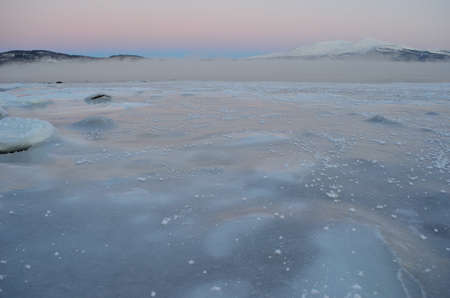 beautiful icy fjord covered in thick ice fog with moon and orange ...