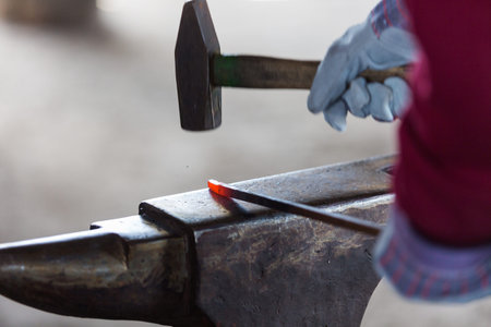 A blacksmith forging hot iron on the anvil. - Stock Image - Everypixel