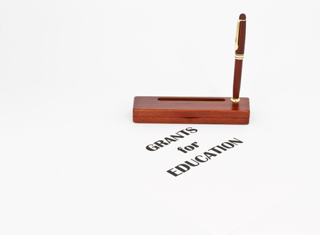 Pen in rosewood stand indicates writing and text directs to grants and ...