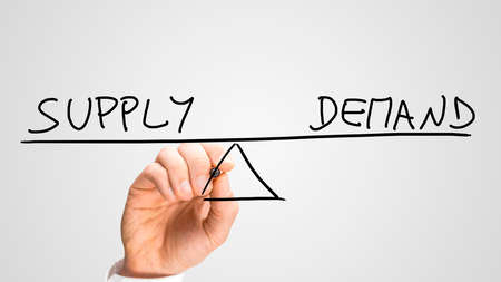 Male hand drawing seesaw with words supply and demand in perfect ...