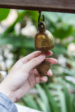 Hand ringing small Thai style bell, typically in temple - Stock Image ...