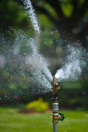 Water springer turning and watering the grass around - Stock Image ...