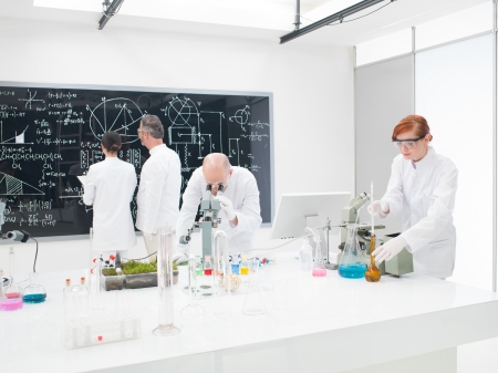 Team of scientists in a laboratory working on chemical testing ...