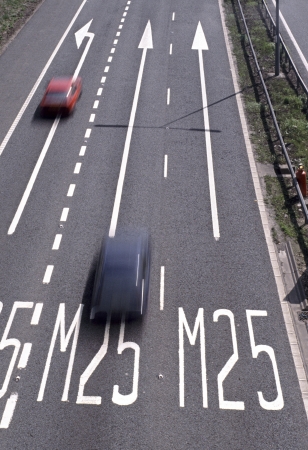 M25 London orbital motorway long arrows signs painted on tarmac with ...
