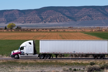 White big rig with crimson fenders and trailer at the field - Stock ...
